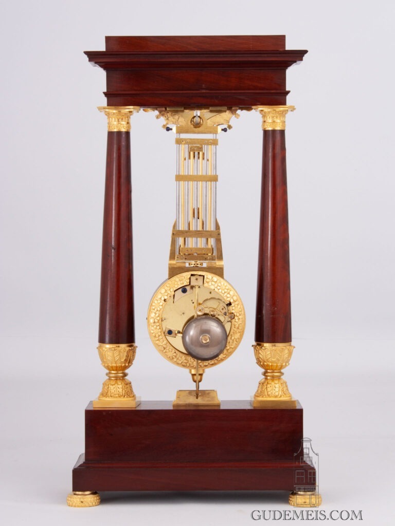 A French late Empire ormolu mounted portico mantel clock with ...
